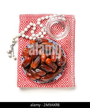 Plate with dates, prayer beads, glass of tea and teapot for Ramadan on ...