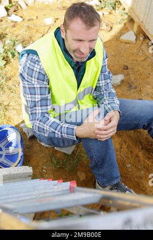 Injured architect sitting on the ground after having fallen off a ...