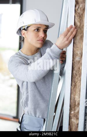female builder installing a wall insulation Stock Photo - Alamy