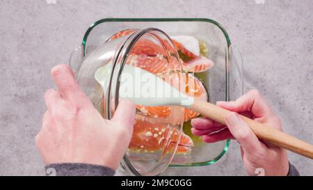 Marinating salmon steaks in a glass dish for grilling Stock Photo - Alamy