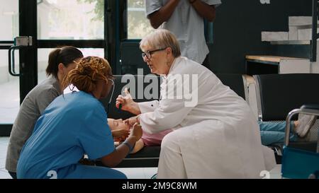 Practitioner doctor helping unconscious child after fainting on chair ...