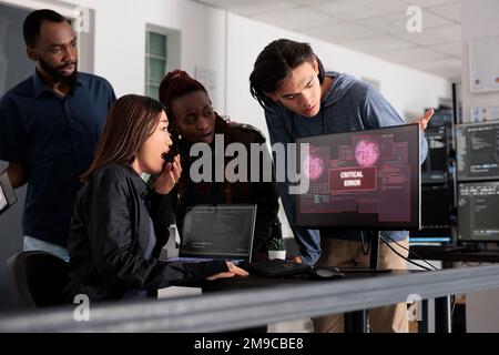 Multi ethnic programmers having security breach alert on computer ...