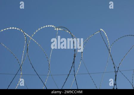 Barbed wire rings on fence. Protected area Stock Photo - Alamy
