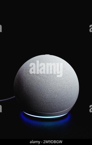A vertical shot of Amazon Echo 4 with neon blue led light on the bottom ...