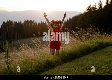 Girl, 8 years, moving in a meadow at sunset, Carinthia, Austria Stock ...