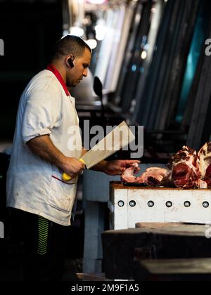 A man chopping meat in a market hall in Athens, Greece Stock Photo - Alamy