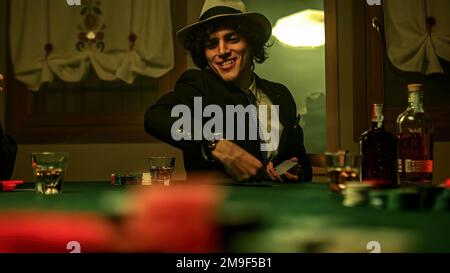 A group of mobsters gather around a table in a dimly lit nightclub. One ...