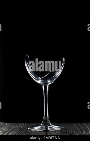 Broken glass goblet. Stands on black boards. Shot on a black background ...