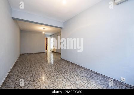 Long empty room with ugly dark tiled floors and pale soft blue painted ...