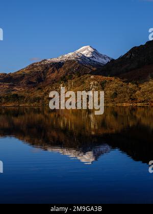 Perfect reflection of snow covered Snowdon Horseshoe mountains in a ...