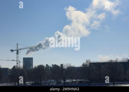 Chimney from which smoke emerges, with a crane in the foreground Stock ...