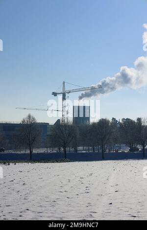 Chimney from which smoke emerges, with a crane in the foreground Stock ...