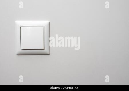 a light switch, a plastic mechanical switch of white color installed on ...