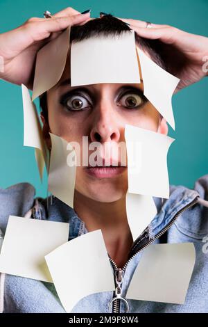Stressed young businesswoman with sticky notes and document folders on ...