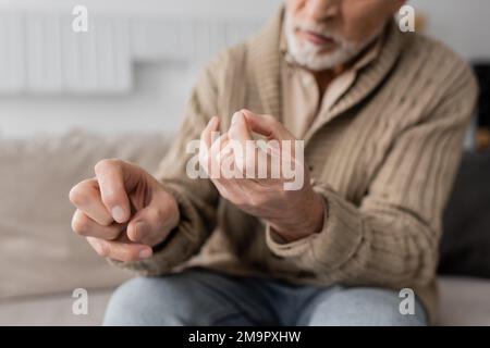 cropped view of aged man with parkinson syndrome and hands tremor ...