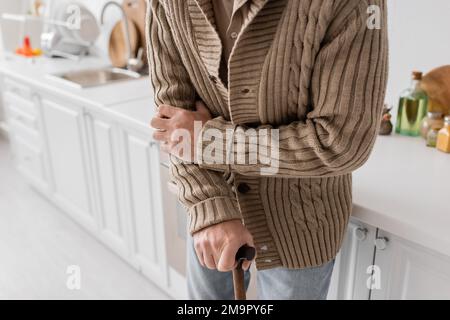 partial view of aged man with parkinson disease holding pills in ...