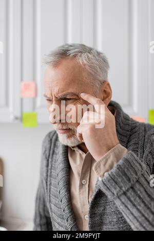blurred thoughtful man with memory loss touching chin while thinking ...