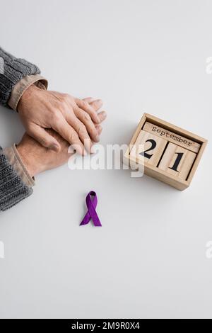 cropped view of aged man with alzheimer disease writing on sticky notes ...