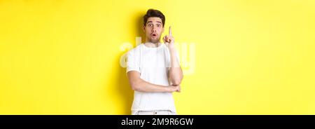 Thoughtful guy suggesting solution, raising finger in eureka sign and ...
