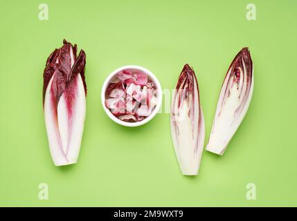 Composition with whole and cut red endive on green background Stock ...