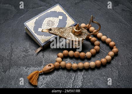 Aladdin lamp of wishes, Koran and prayer beads for Ramadan on blue ...
