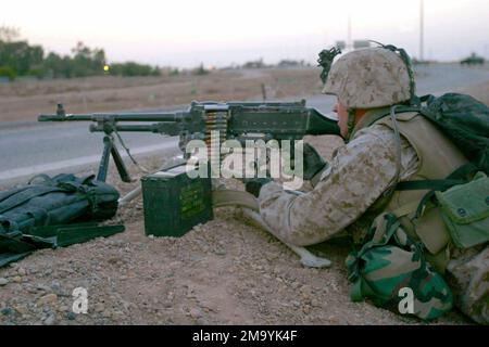 A US Marine mans a M240G machine gun in the prone position and carries ...