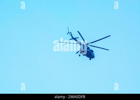 Combat helicopter is flying against isolated blue sky. Combat ...