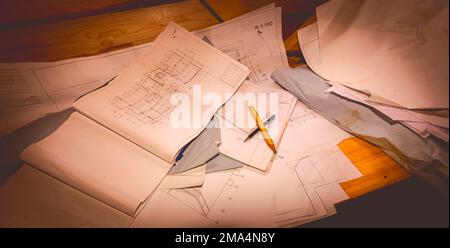 Mason's work desk in wooden cabin with pile of architectural drawings ...