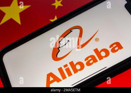 The logo of Alibaba seen in an iPhone on Chinese flag background ...