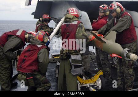 US Navy Aviation Ordnancemen (AO) Edward Green, (left) AO David Butts ...