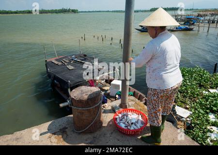Small fishing pier on the Thu Bon River where a fishing boat is ...