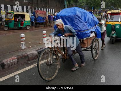 DELHI, INDIA - OCT 10: Rickshaw rider transports passenger on October ...