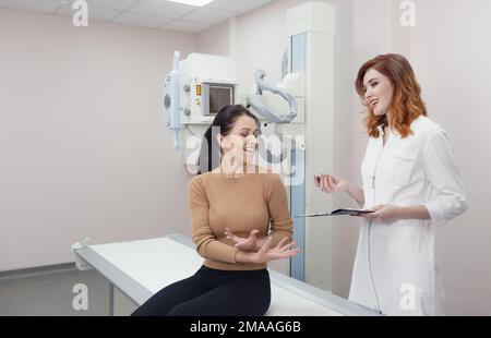 a female radiologist communicates with a patient in the X-ray room ...