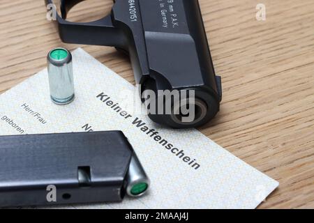 A closeup shot of a small black Rohm brand pistol and a german license ...