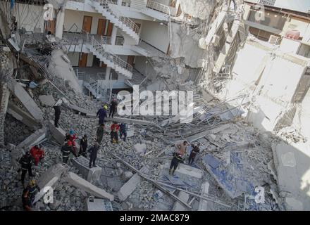 Iraqi emergency and rescue personnel search for survivors in the rubble ...