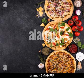 Assortment of various type of Italian pizza on a black background, top ...