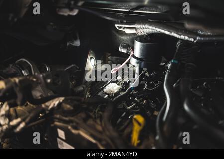 Mechanic removes a stuck injector in a diesel engine with the press in ...