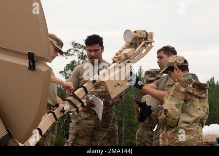 Members of the 147th Combat Communications Squadron attach power to a ...