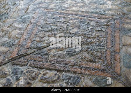 Portrait of water ripples on the floor of the yard that has a rocky ...