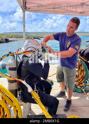 Hospital Corpsman 1ST Class (Diver) Raymond Gwaltney examines a patient ...