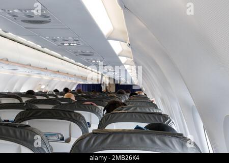 Passenger plane cabin interior view with people Stock Photo - Alamy