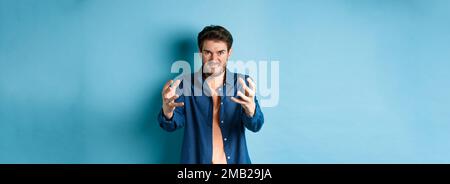 Angry tensed man wants to strangle someone, stretch out hands to choke ...