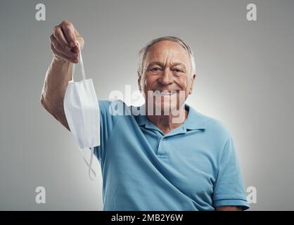 Man without protective face-mask using power tool sanding wood tops of ...