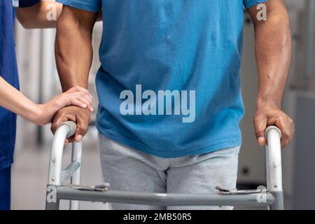 Modsection of diverse female doctor helping senior male patient use ...