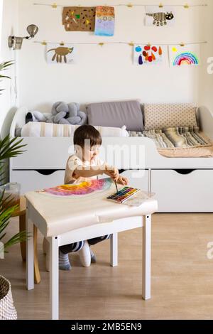 Confident cute male kid art drawing multicolored rainbow arch use ...