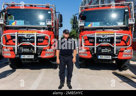 A Romanian firefighter stands in front of a fire engine during a ...