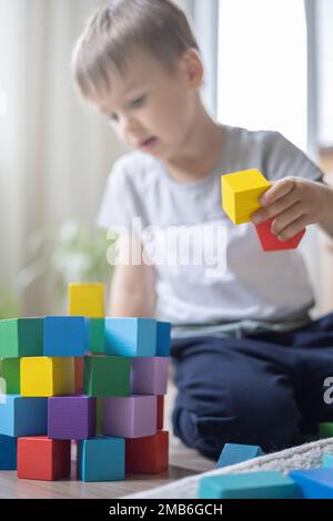 Confident male kid building fortress tower architecture and forest with ...