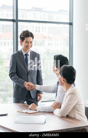 Business people standing upright while shaking hands and smiling Stock ...