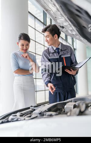 Repair shop mechanics of personnel with the customer Stock Photo - Alamy