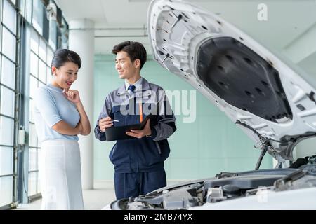 Repair shop mechanics of personnel with the customer Stock Photo - Alamy